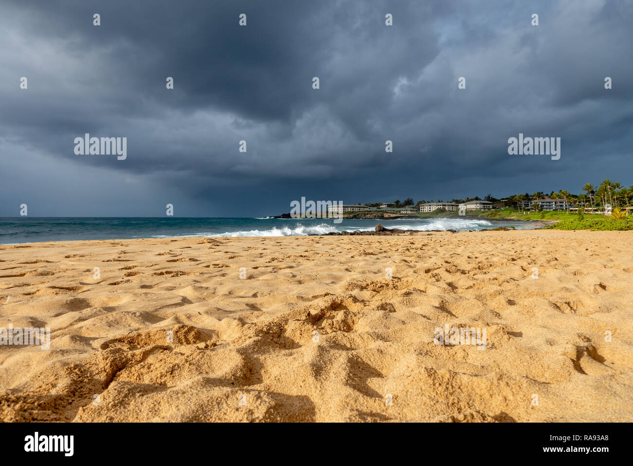 Warm Yellow Sandy beach under Dark Gray Sky, Kauai Stock Photo - Alamy