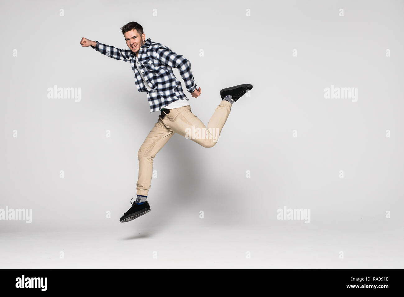 Full length portrait of a young man jumping with hands outstretched ...