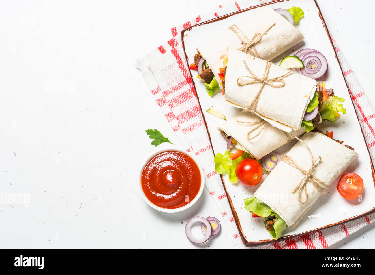Burritos tortilla wraps with beef and vegetables on white background ...