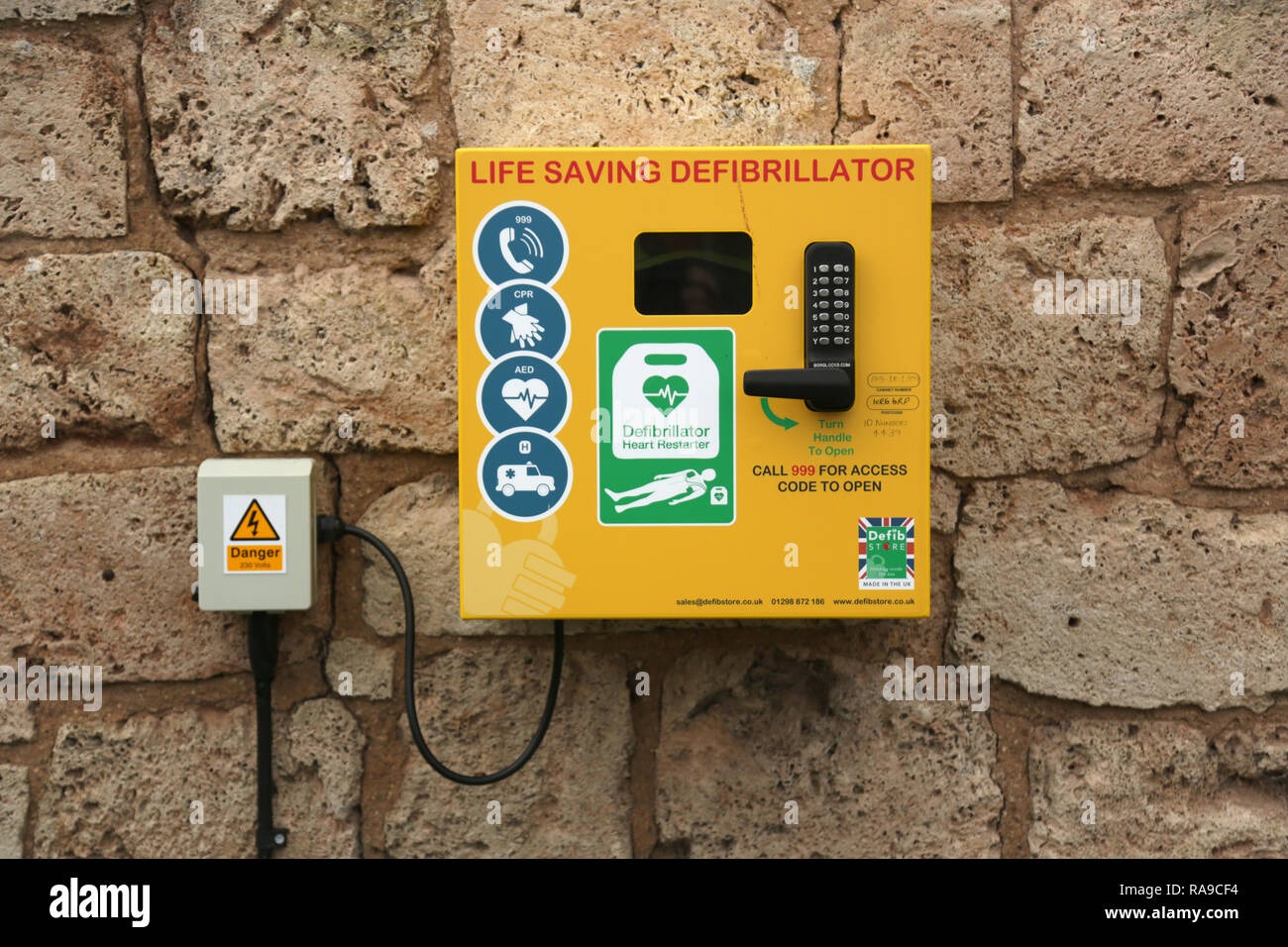 A defibrillator for public use mounted outside on a stone wall Stock ...