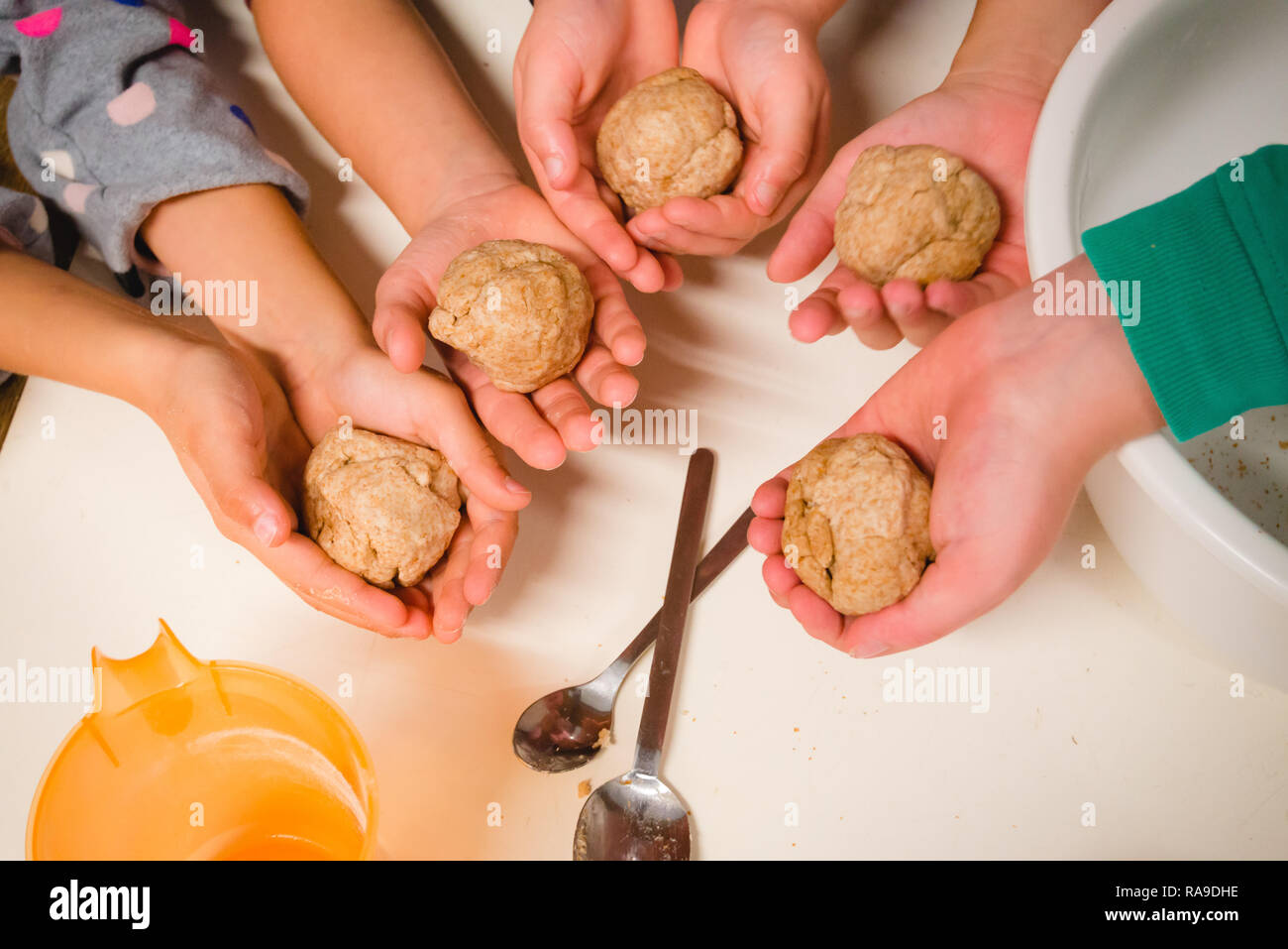 Close up to hands of children who learn how to bake from raw corn to ...