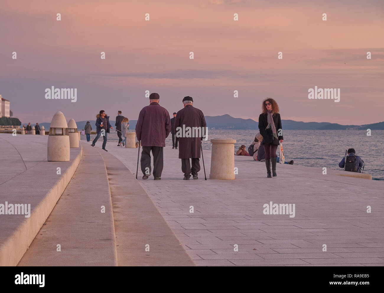 Locals enjoying a sunset walk on the city water front developed walkway ...