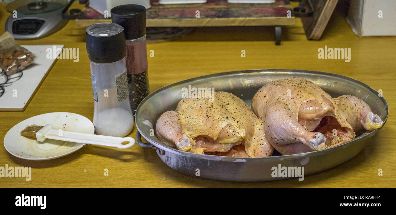 Whole chickens being prepared in a home kitchen to be cooked for a meal ...