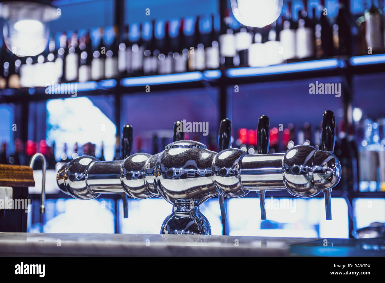 Close up of metal beer dispensers faucet in a row at bar counter, out ...