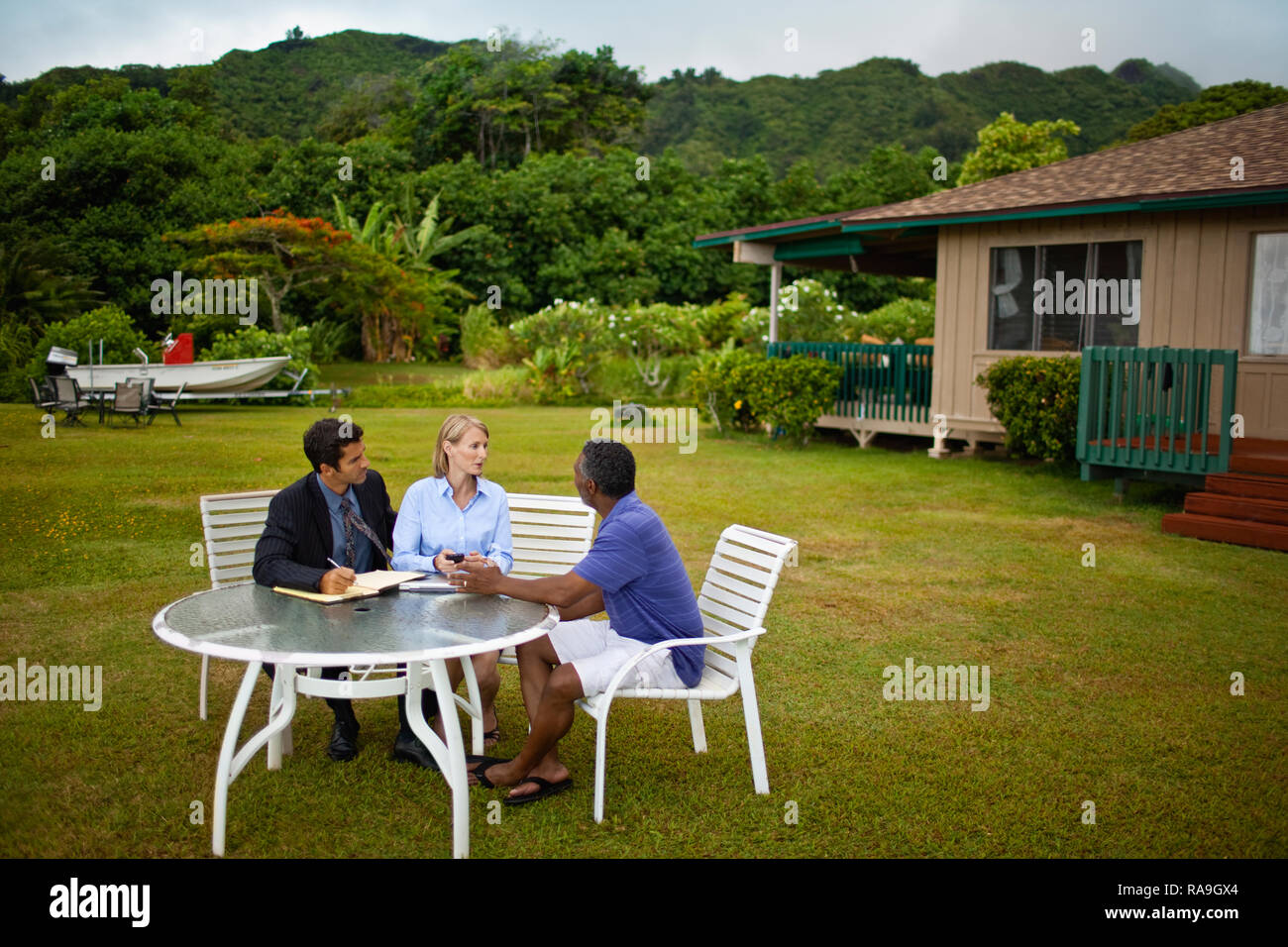 Mature man filling out paperwork with the help of real estate agents ...
