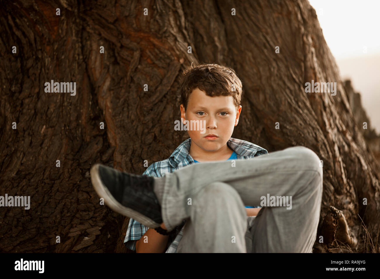 Three children sitting under tree hi-res stock photography and images ...