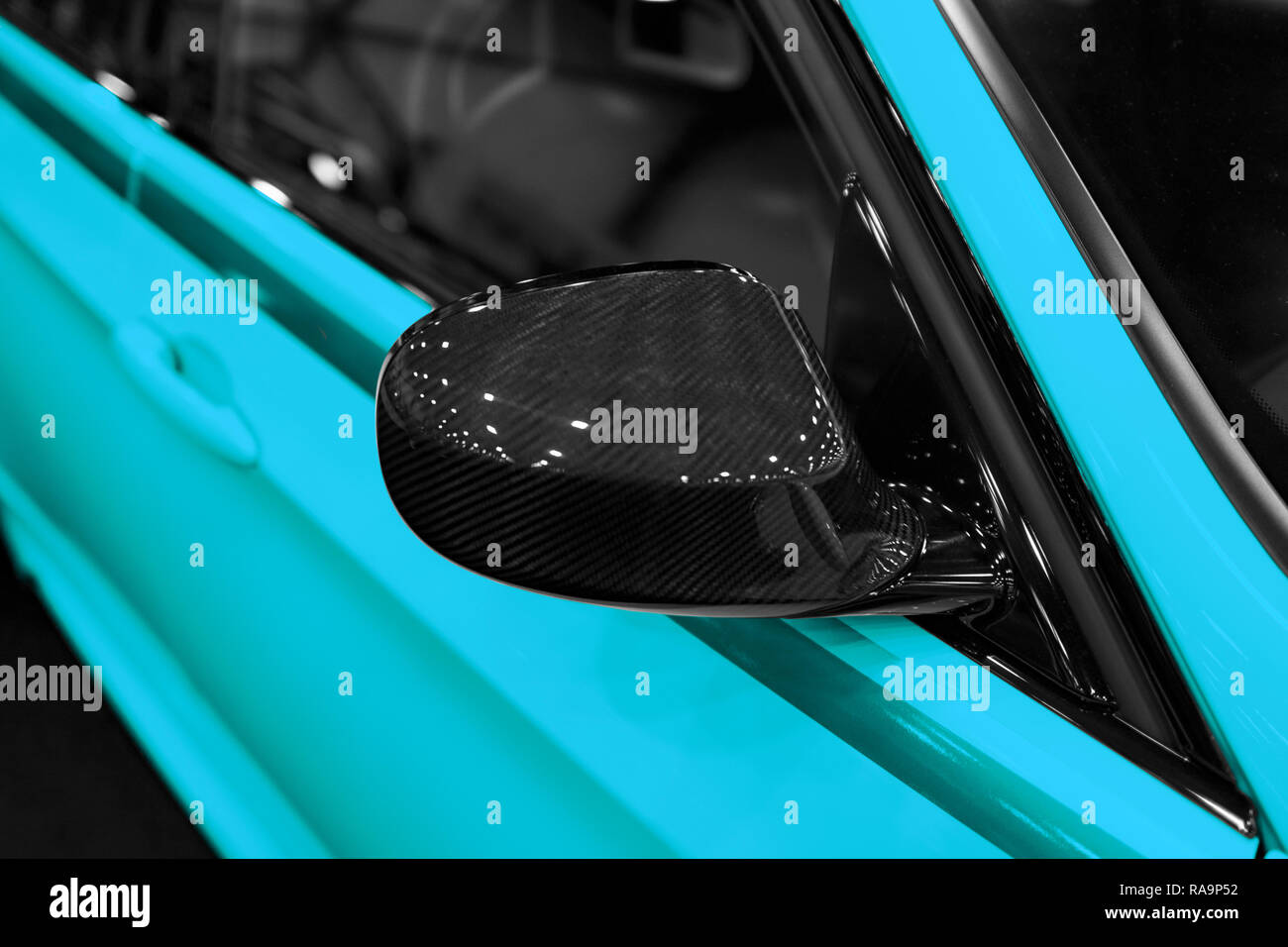 Carbon Right side Car mirror with reflection of a blue modern car. Car ...