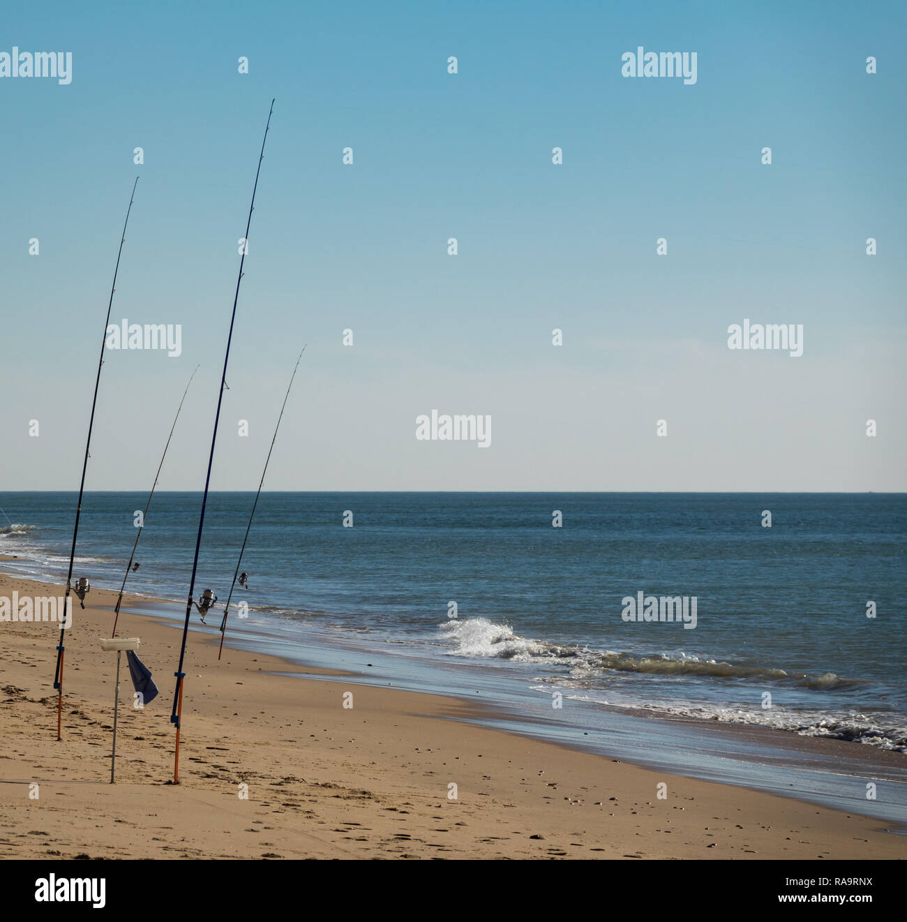 Fishing rods fishing in the beach as automaton machines Stock Photo - Alamy