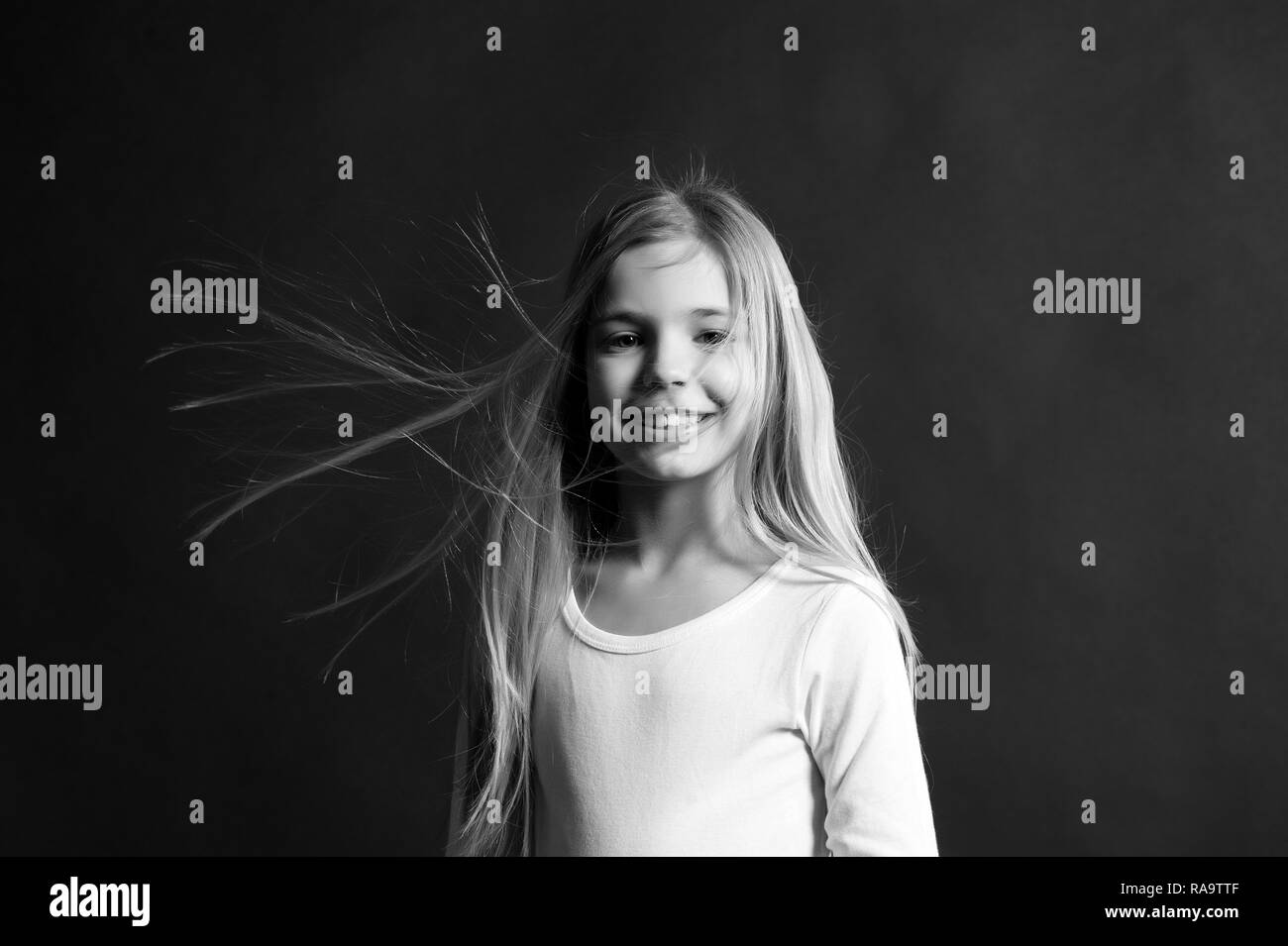 Fashion, look, hairstyle. Child model smiling with blowing long hair ...