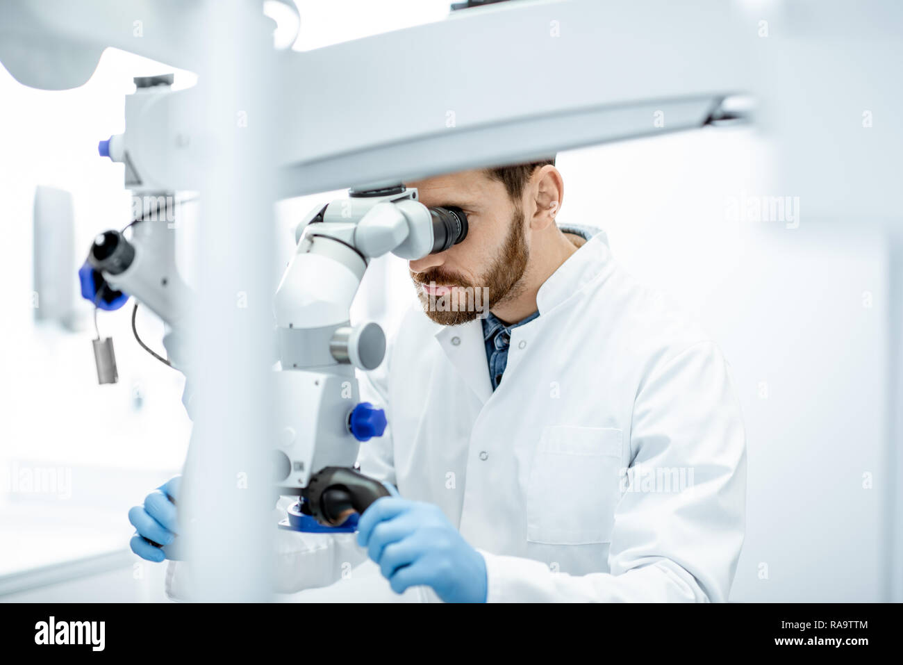 Male dentist examining patient looking on the teeth with professional ...