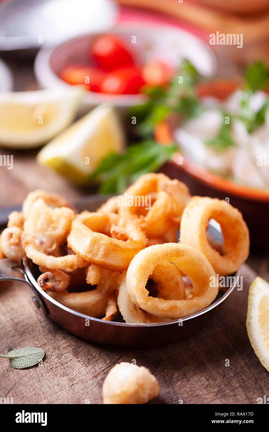 Crispy calamari rings on a rustic table Stock Photo - Alamy