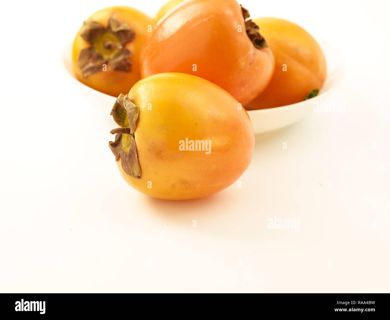 Sharon fruit against white background, food portrait Stock Photo - Alamy