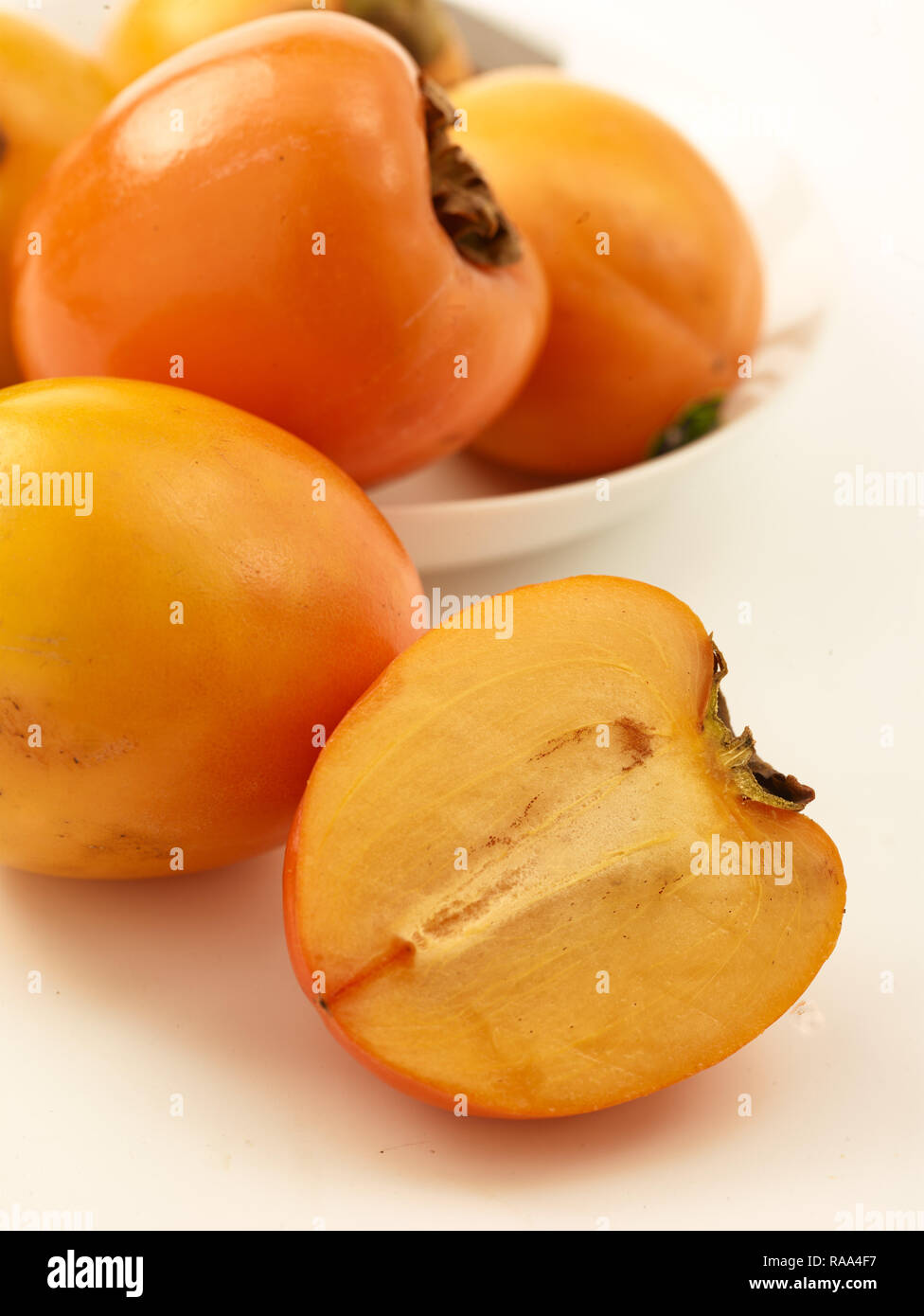 Sharon fruit against white background, food portrait Stock Photo - Alamy