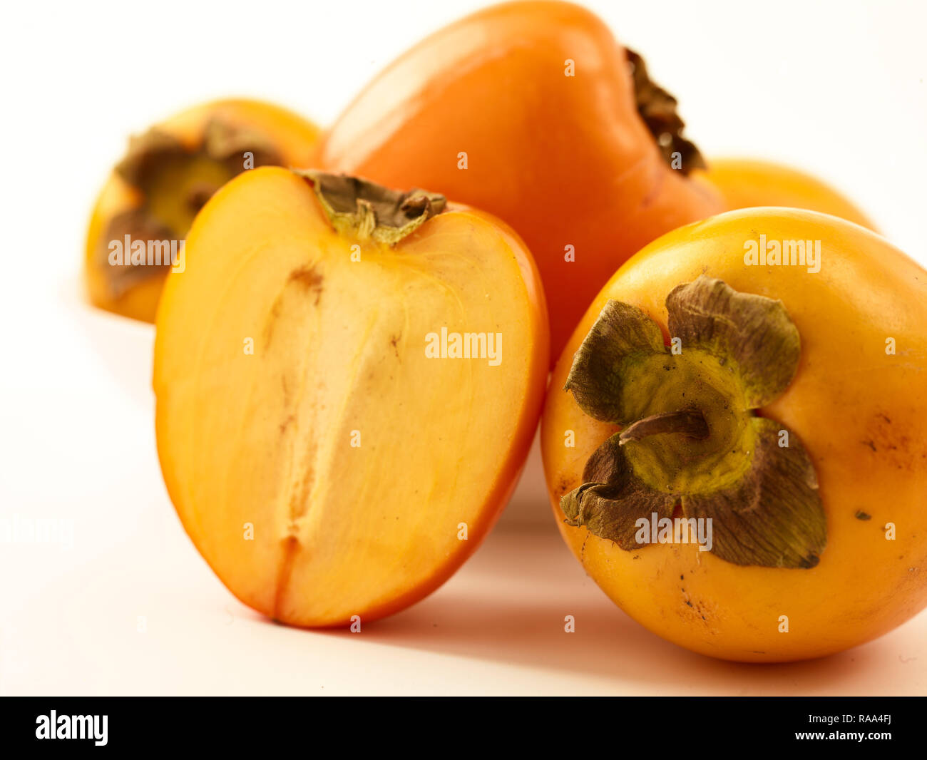 Sharon fruit against white background, food portrait Stock Photo - Alamy