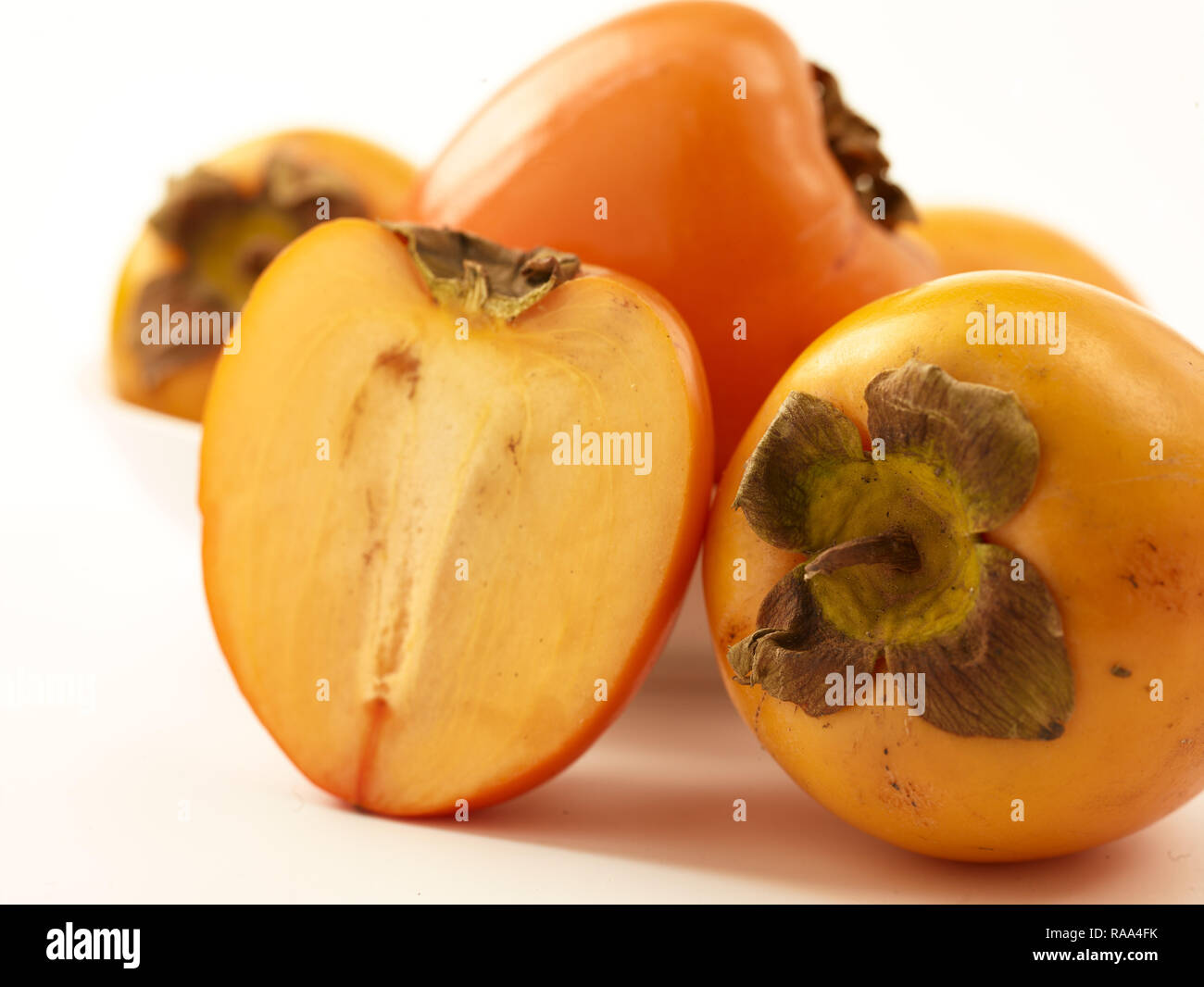 Sharon fruit against white background, food portrait Stock Photo - Alamy