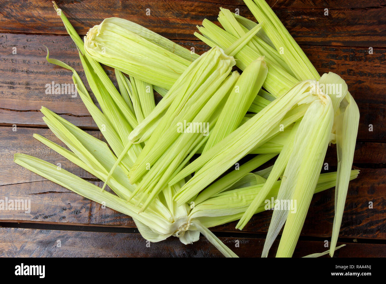 bark and green corn straw, harvested from plantation, on rustic wooden ...