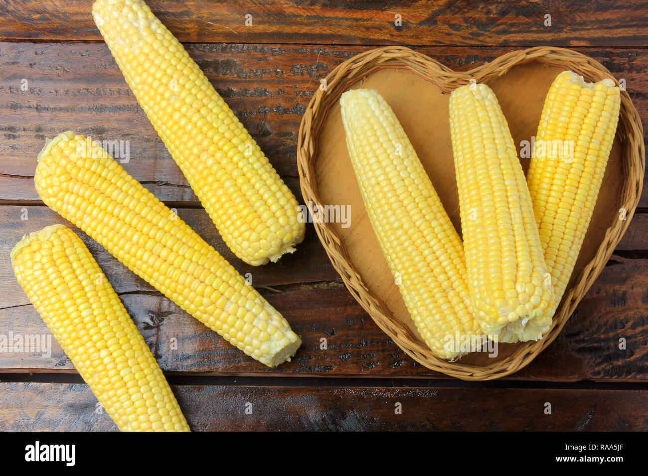 Corn cob, fresh, harvested from plantation inside basket with heart ...