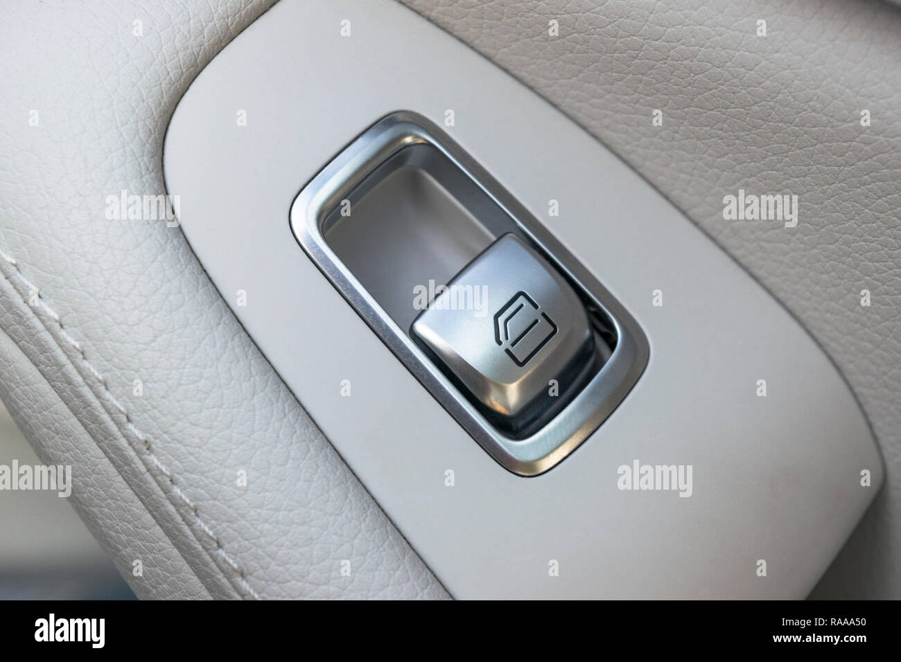Car white leather interior details of door handle with windows controls ...