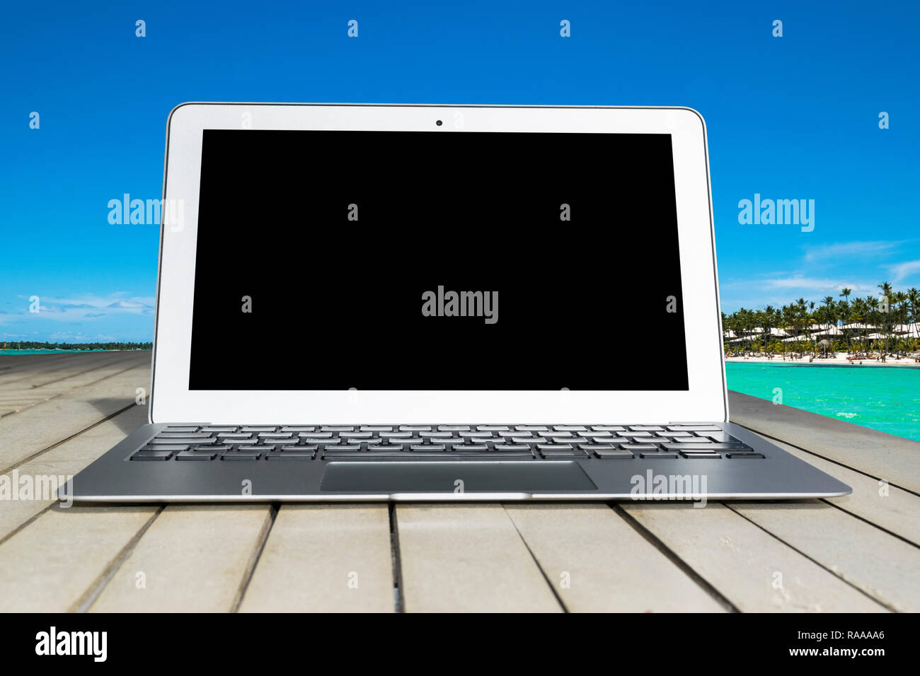 Laptop computer on wooden table. Top ocean view. Tropical island ...