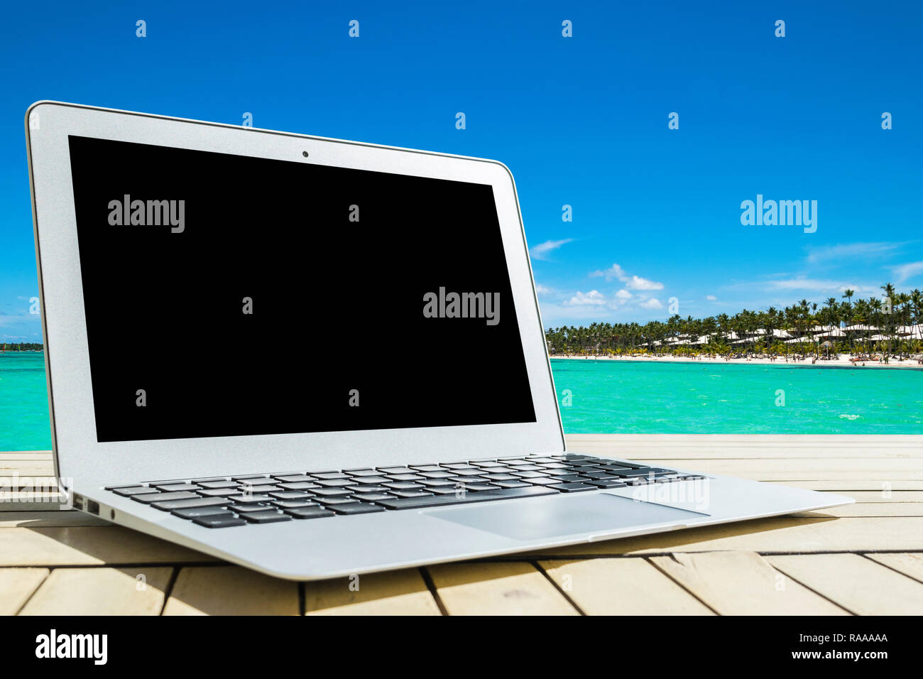 Laptop computer on wooden table. Top ocean view. Tropical island ...