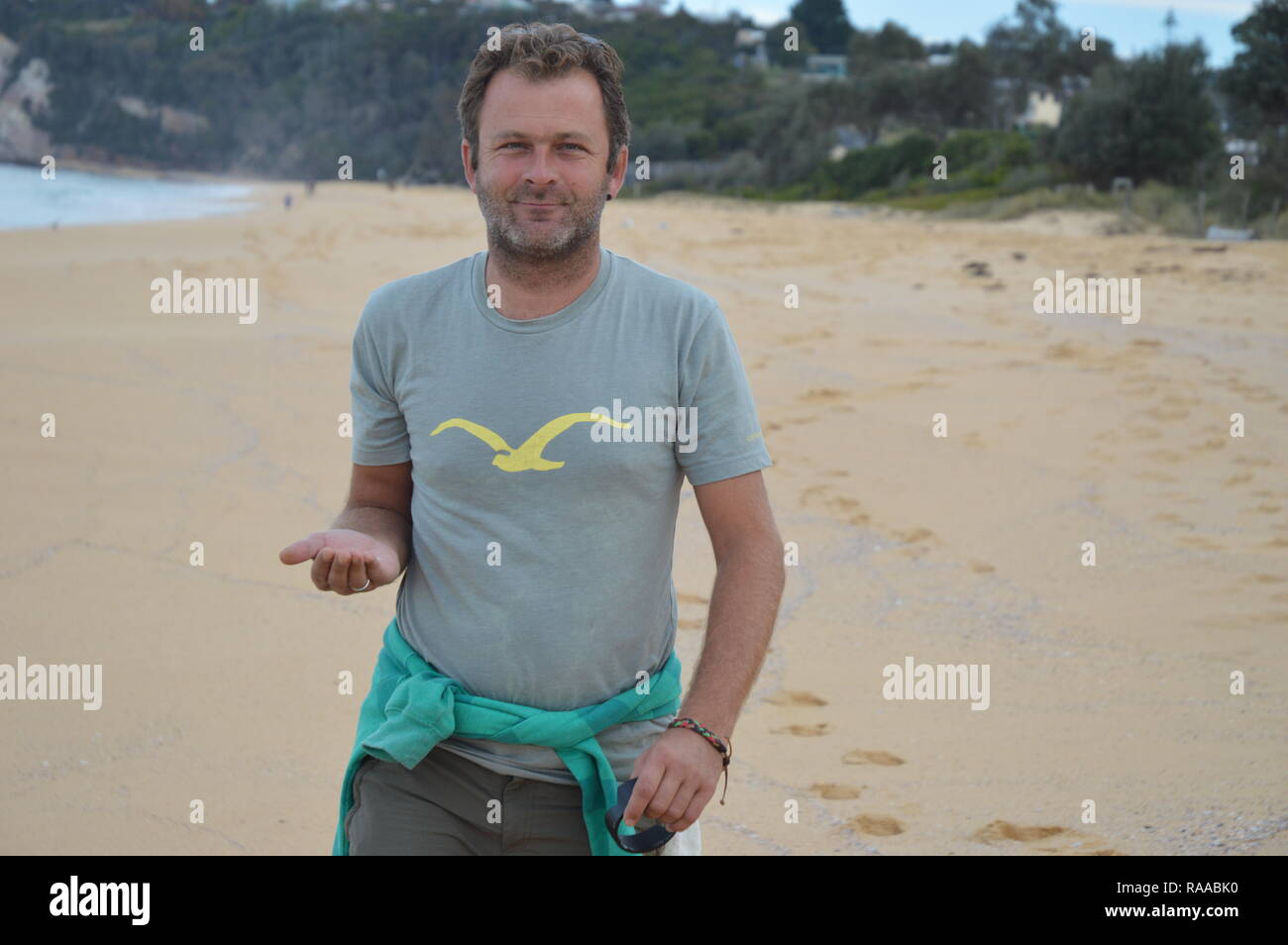Man walking on a beach with palm raised Stock Photo - Alamy
