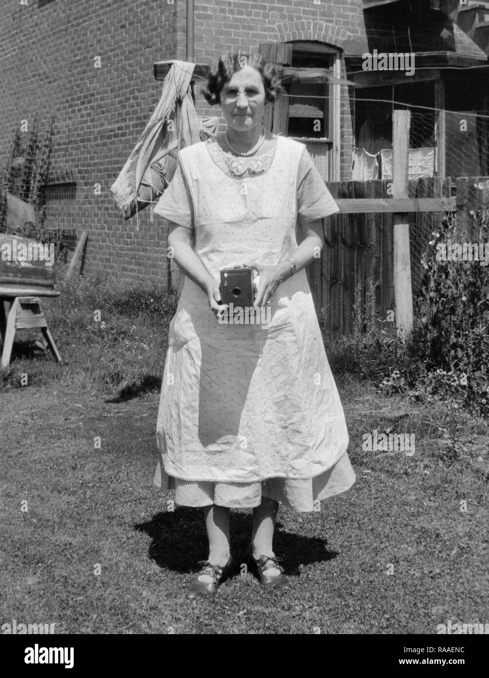 A woman stands with a modern box camera of the day, 1926 Stock Photo ...