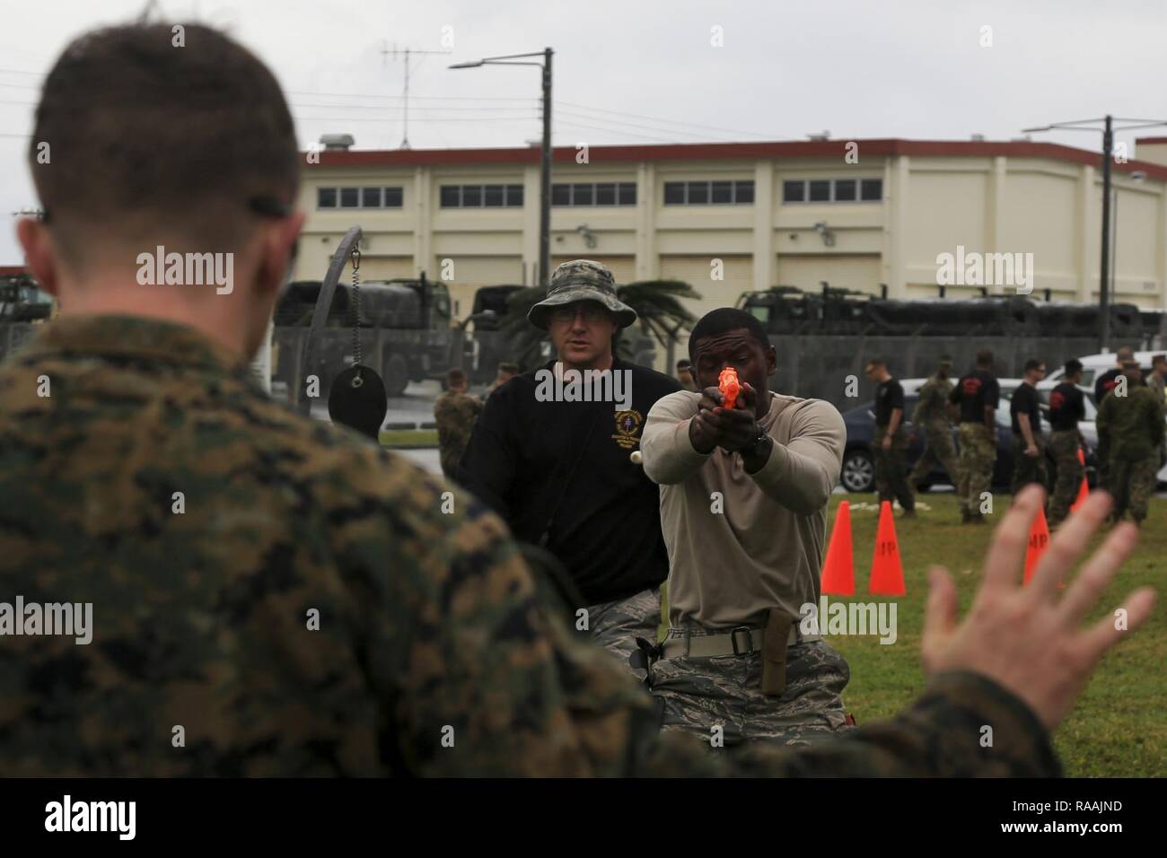 U.S. Airmen Staff Sgt. Lionel Rhone, military police, points his pistol ...