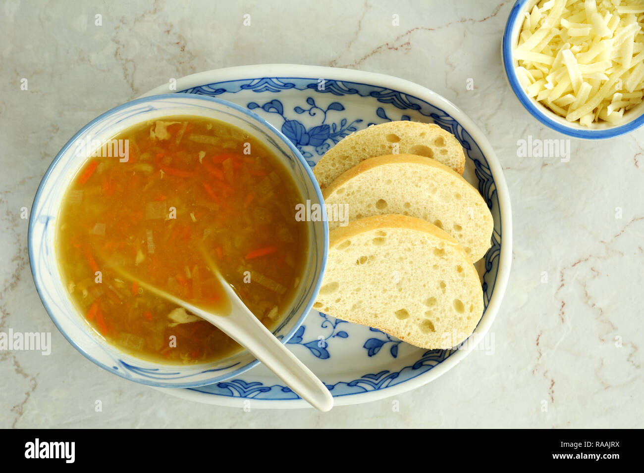 Home made chicken vegetable soup with bread and shredded cheese shot ...