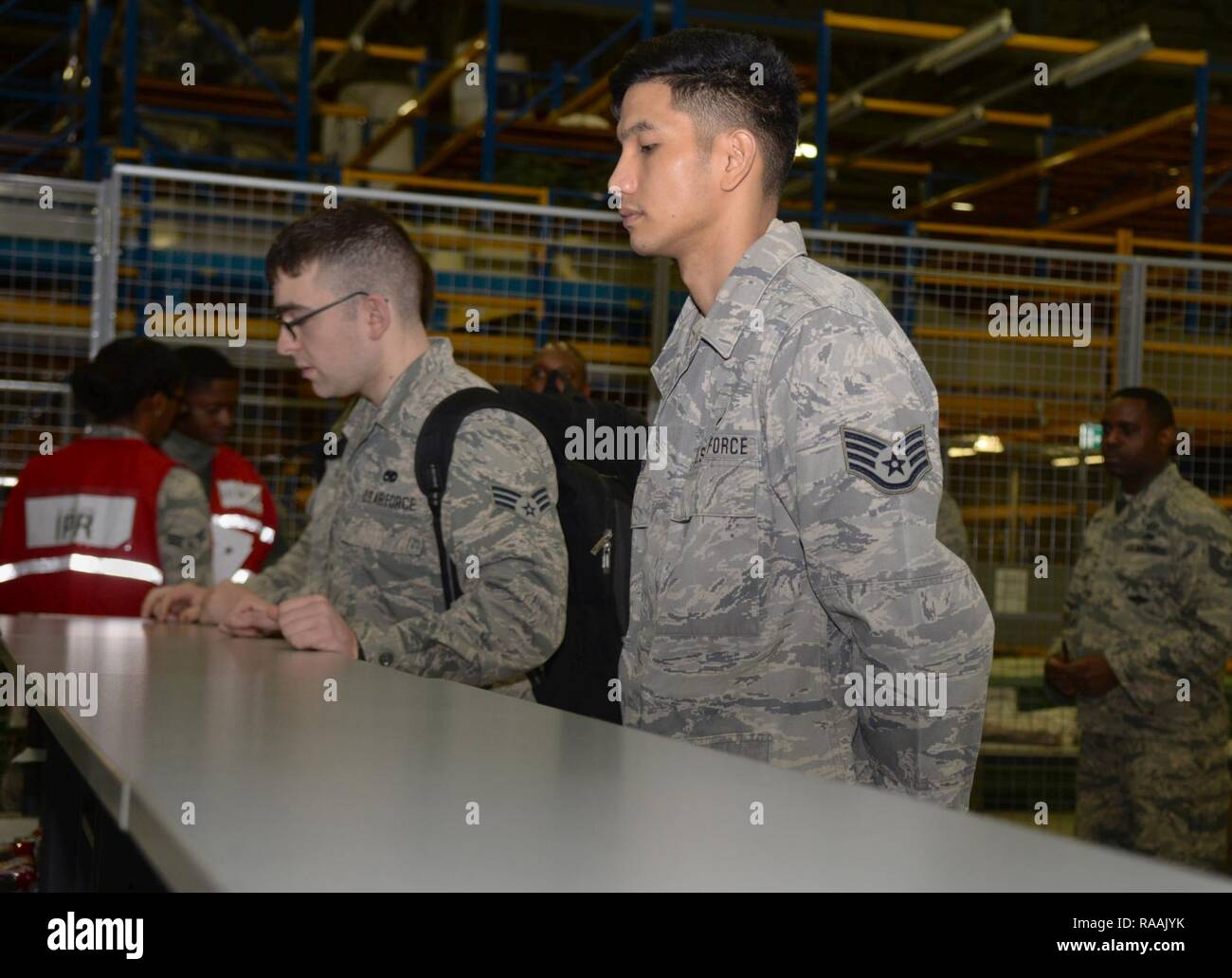 U.S. Air Force Airmen proceed through the personnel deployment function ...