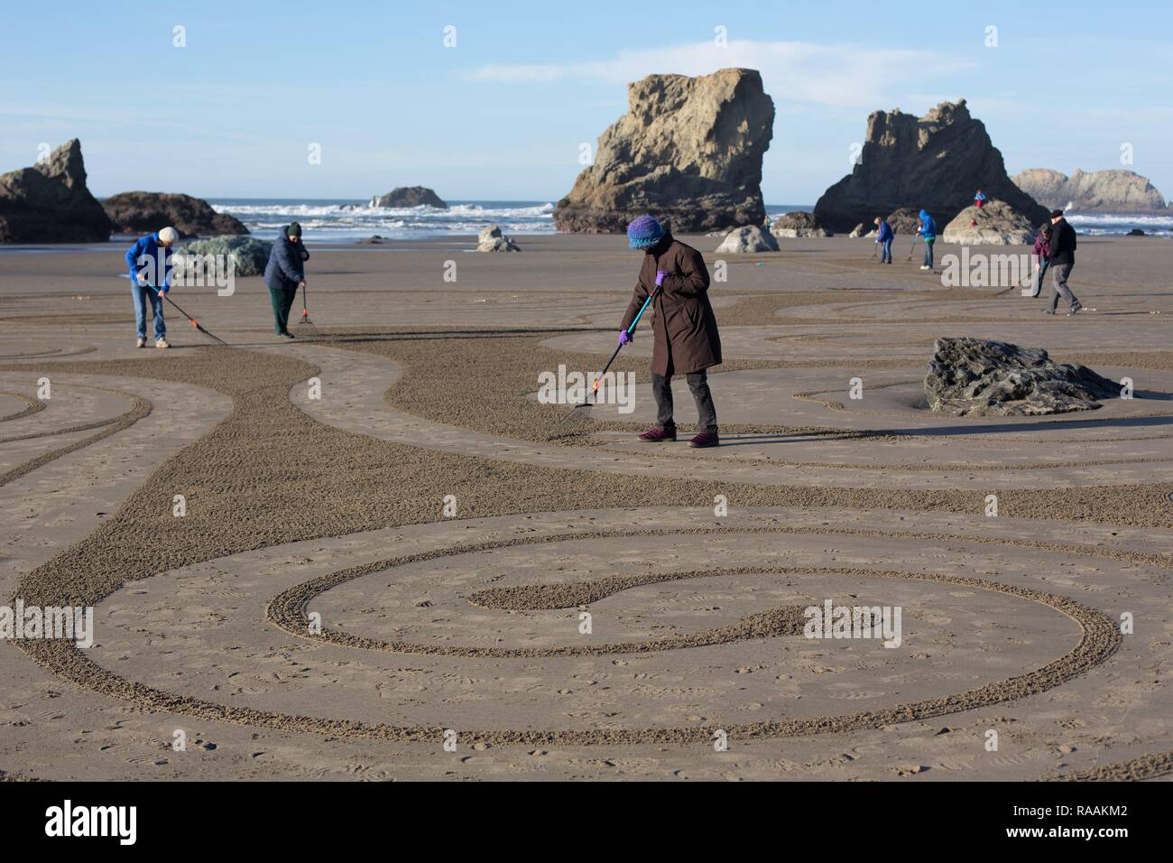 Volunteer artists working on a sand labyrinth created by the group ...