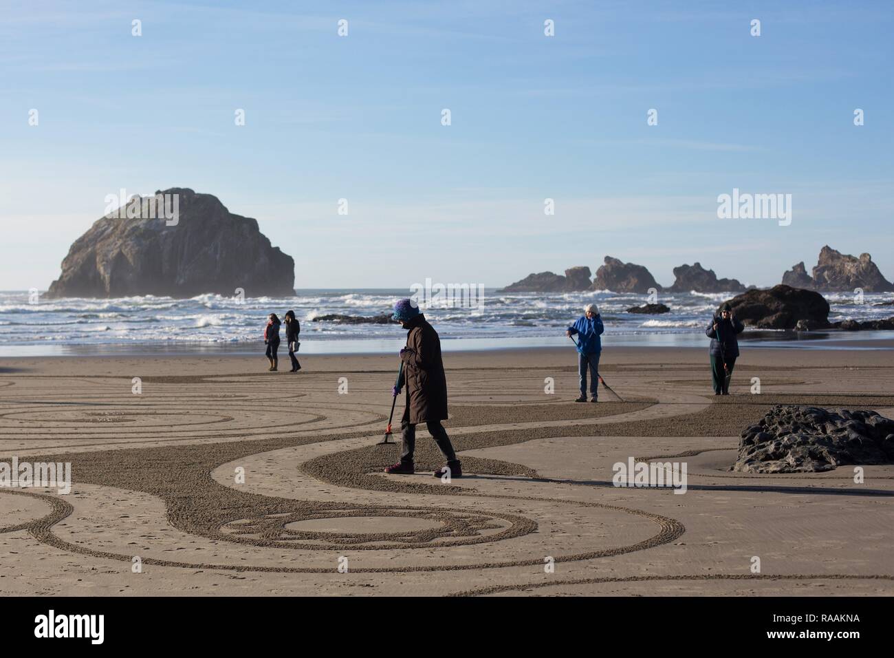 Volunteer artists working on a sand labyrinth created by the group ...