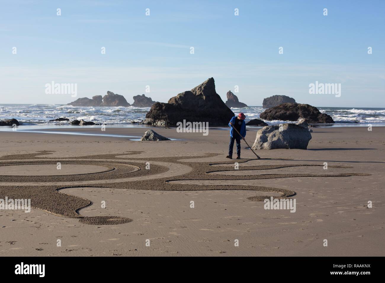 A volunteer artist working on a sand labyrinth created by the group ...