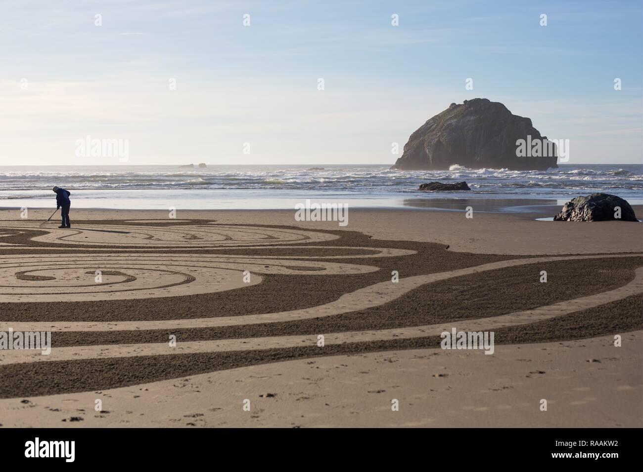 A volunteer working on a sand labyrinth created by the group "Circles ...