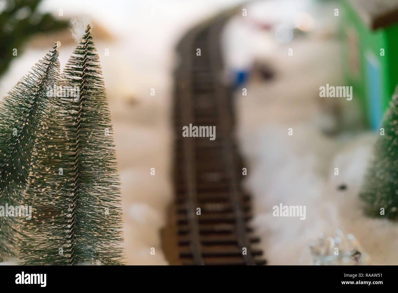 Two Christmas trees on a model train track with snow and copy space for ...