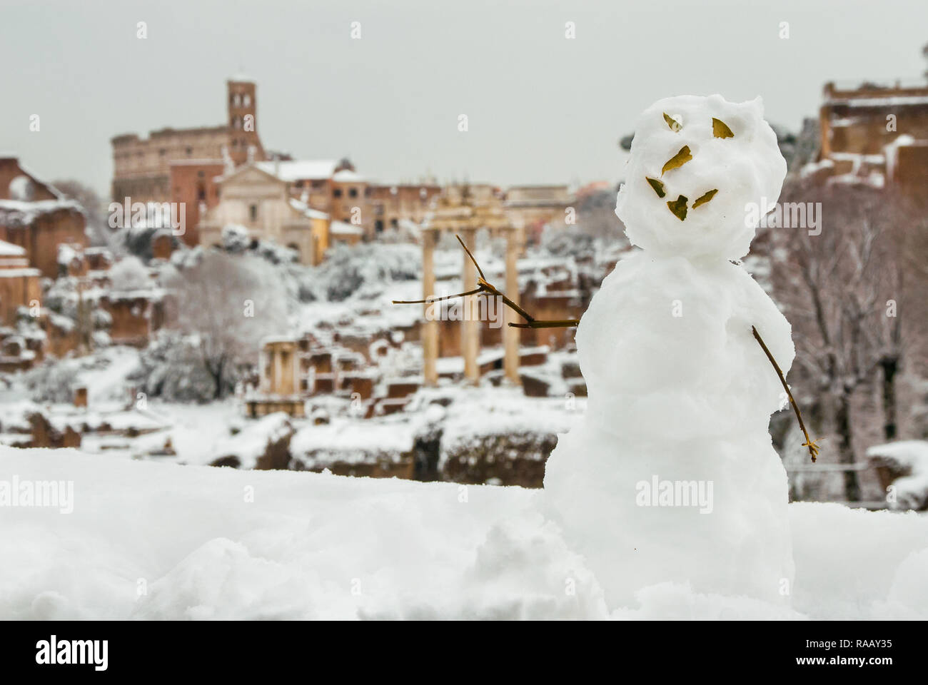 Snowman shows Roman Forum ancient monuments and Coliseum with snow ...