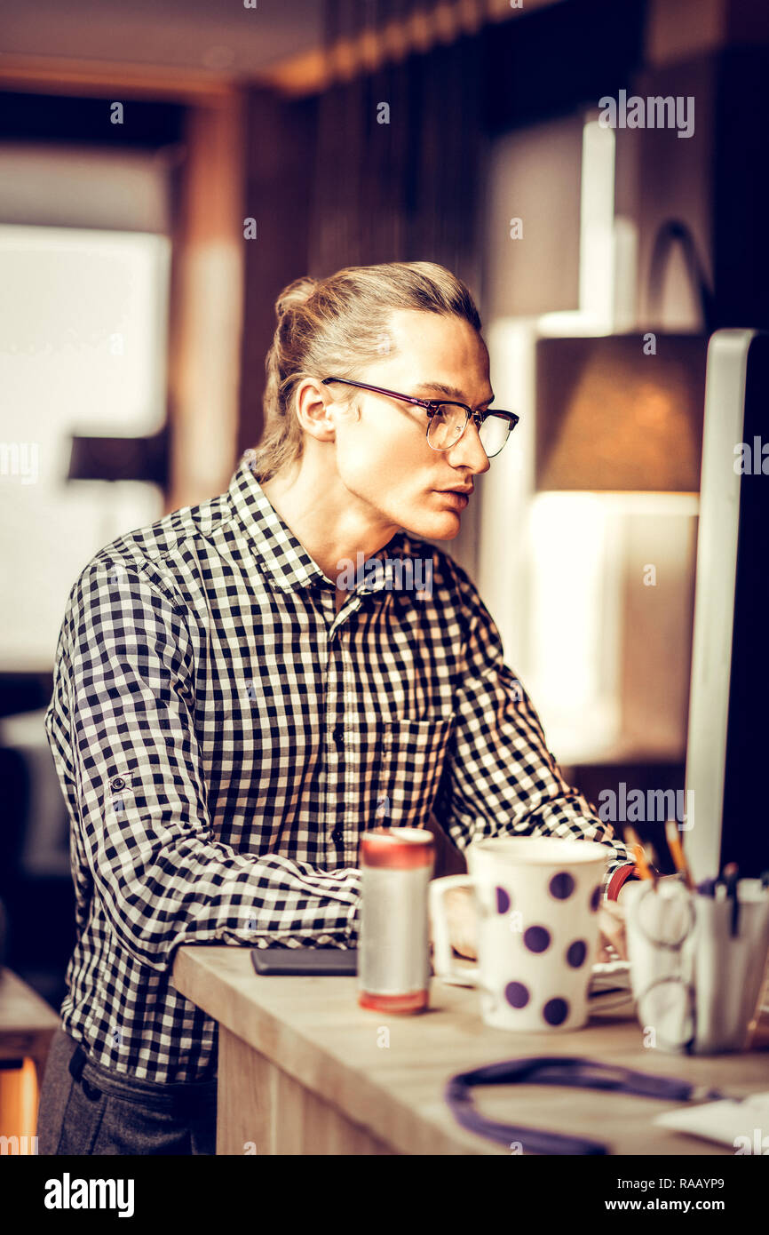 Serious young man working at project alone Stock Photo - Alamy