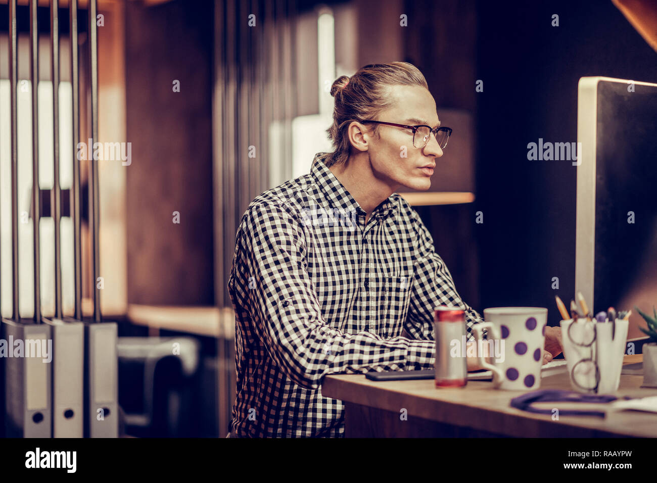 Handsome blonde man staring at his computer Stock Photo - Alamy