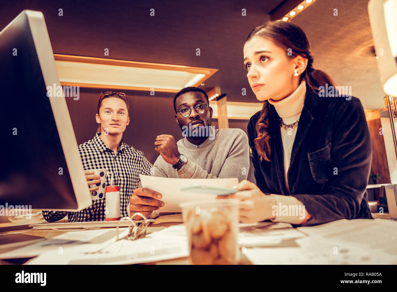 Attentive young female person looking at screen of computer Stock Photo ...