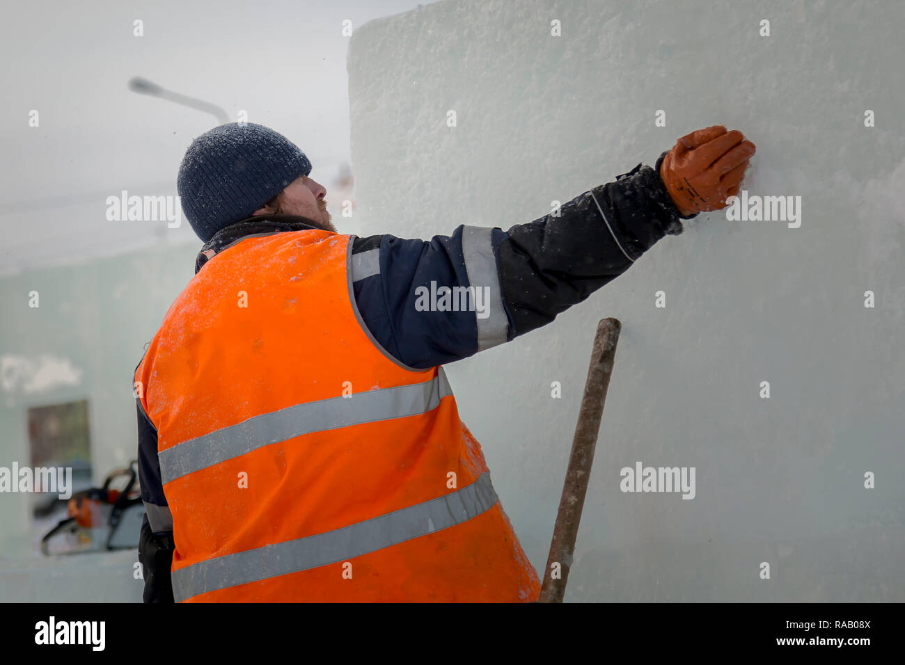 The installer at the construction site of the ice town covers the ...