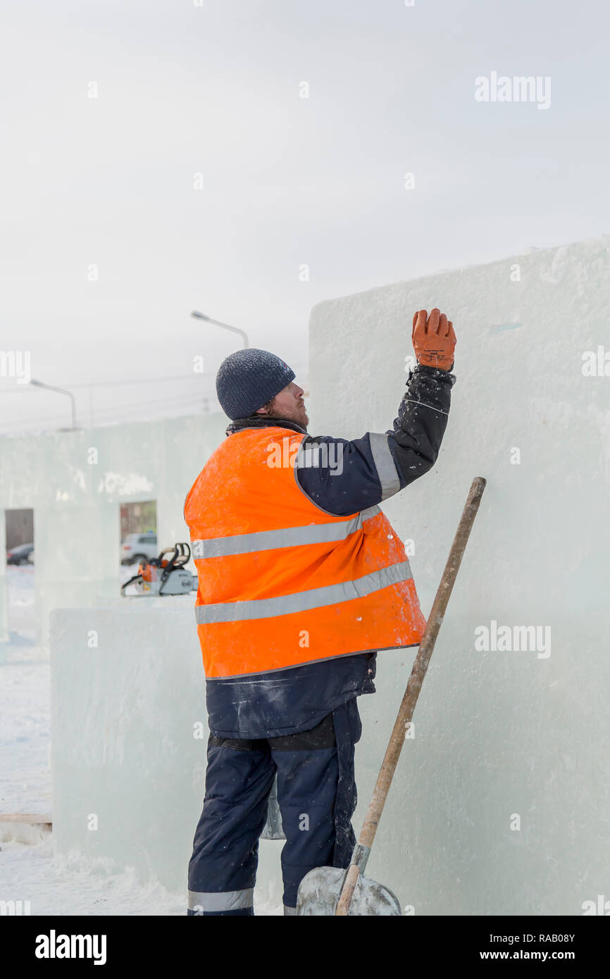 The installer at the construction site of the ice town covers the ...