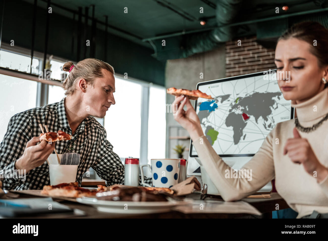 Relaxed young people eating pizza during break Stock Photo - Alamy
