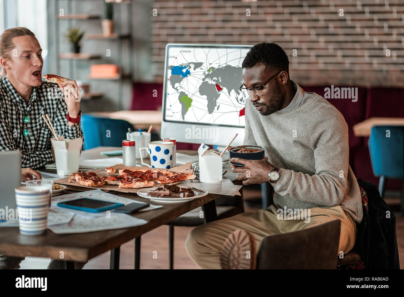 Busy young males having dinner during work Stock Photo - Alamy