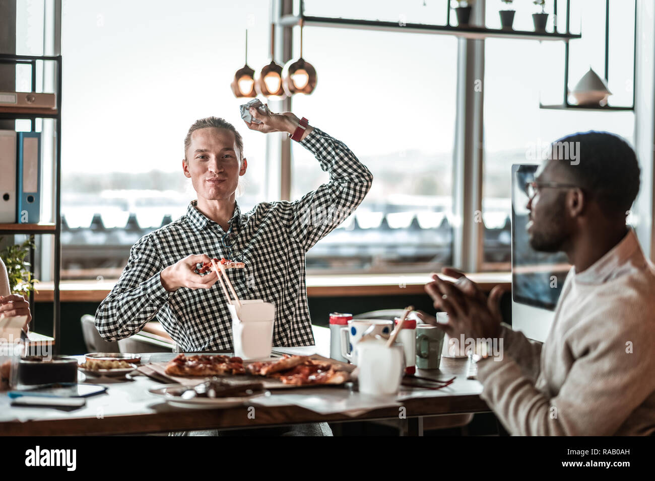 Kind blonde male throwing paper ball forward Stock Photo - Alamy