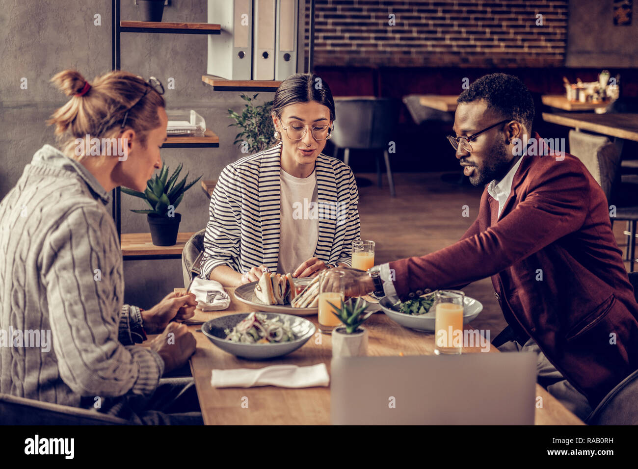 Kind office workers enjoying tasty dinner in cafe Stock Photo - Alamy