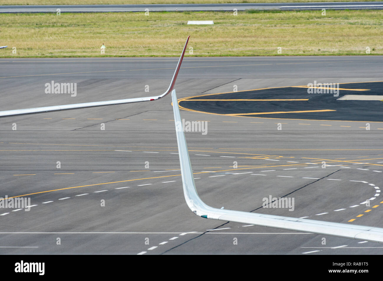 Winglets from two modern passenger aircraft against a runway background ...