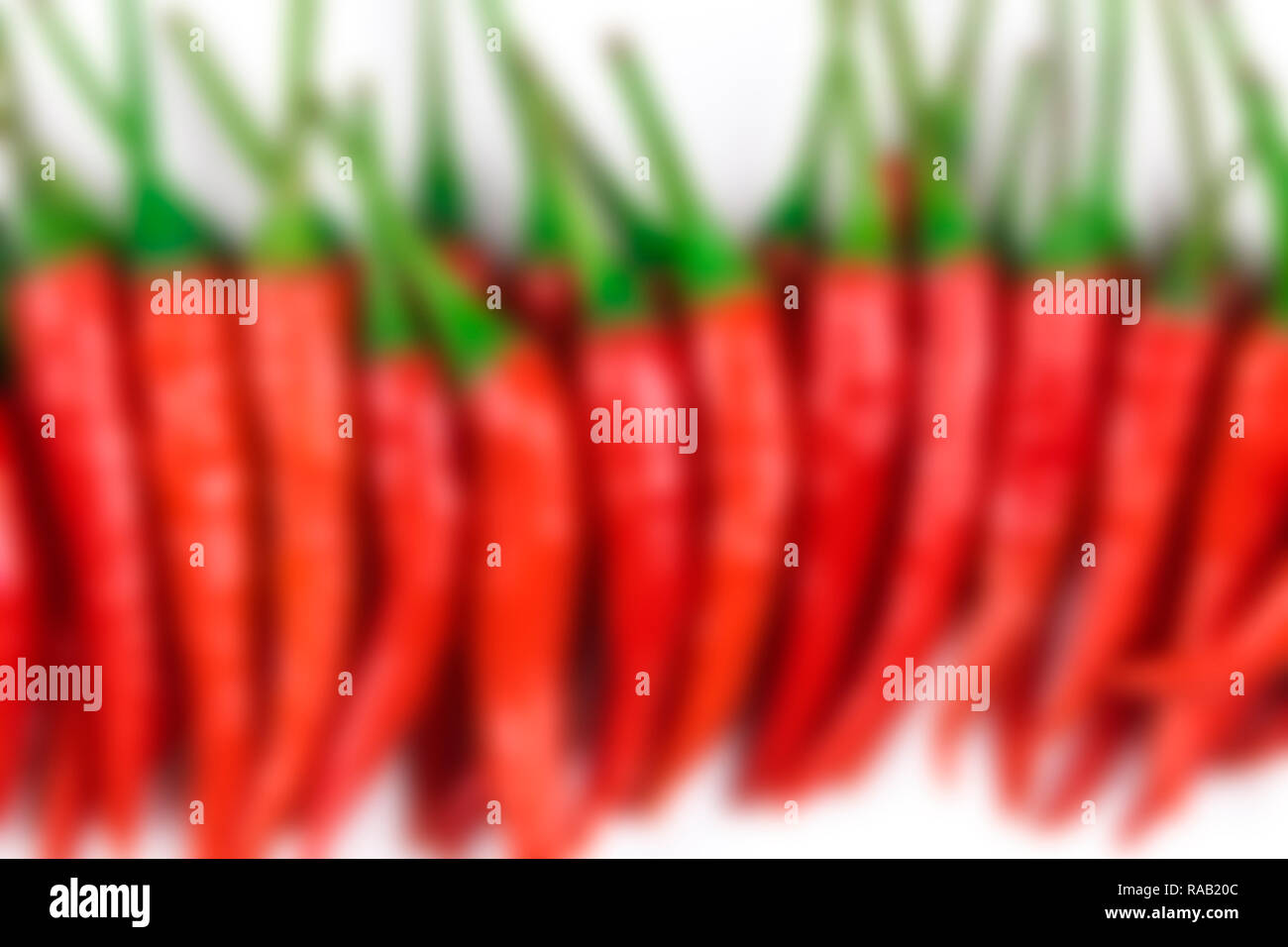 Blurred bacground with Fresh pods of red chili peppers on white ...