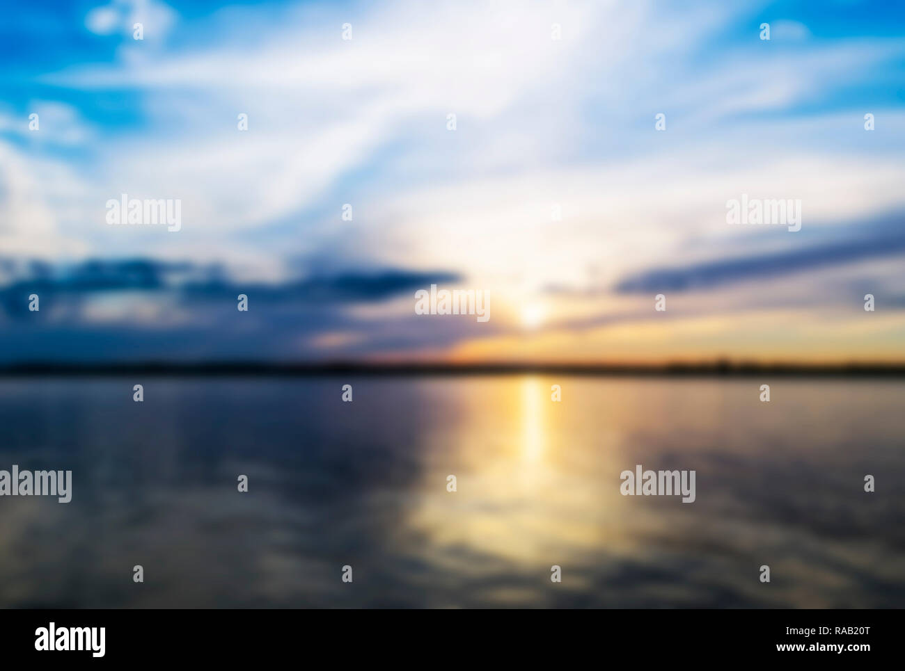 Blurred background with Sunset over the ocean through clouds, blur gold ...