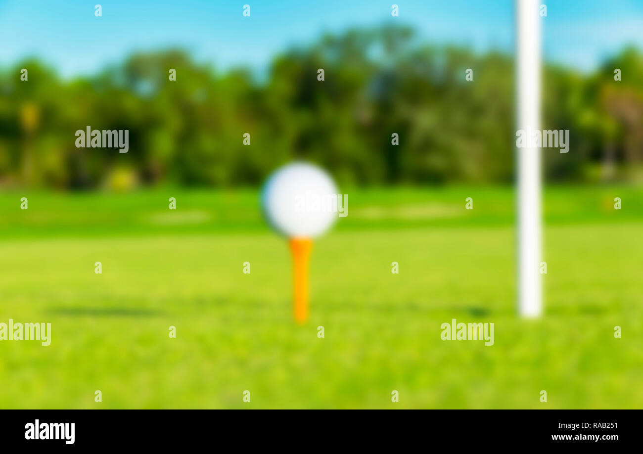 Blurred background with Golf ball on tee on golf course over a blurred ...
