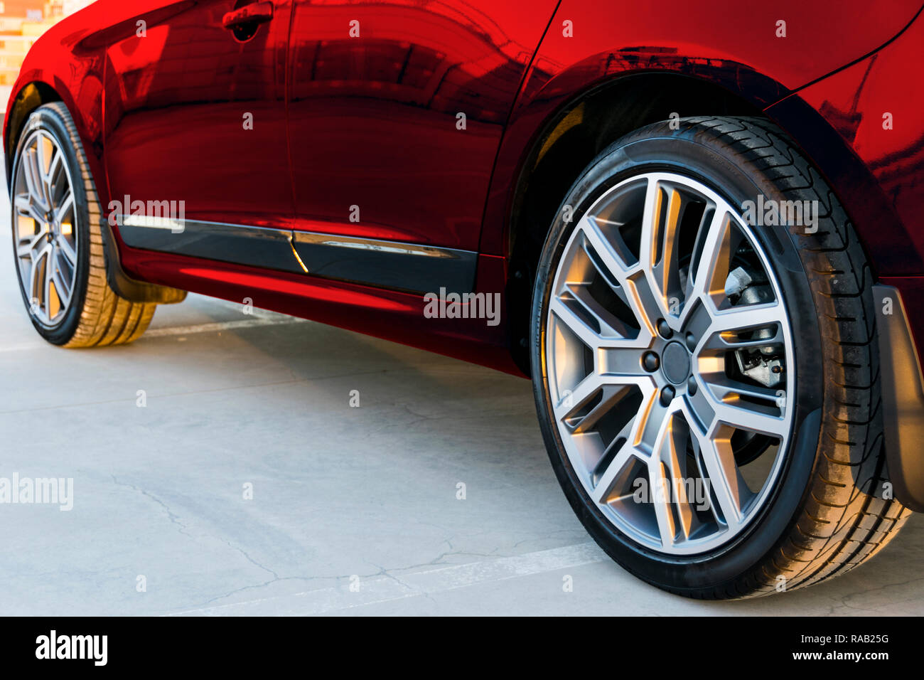 Side view of a car. Tire and alloy wheel of a modern red car on the ...