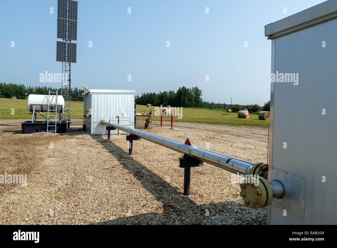 Pipeline between two metal buildings Stock Photo - Alamy